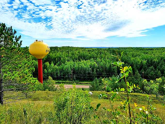 The iconic yellow water tower stands sentinel over the landscape, a cheerful landmark guiding travelers to this hidden Iron Range treasure.