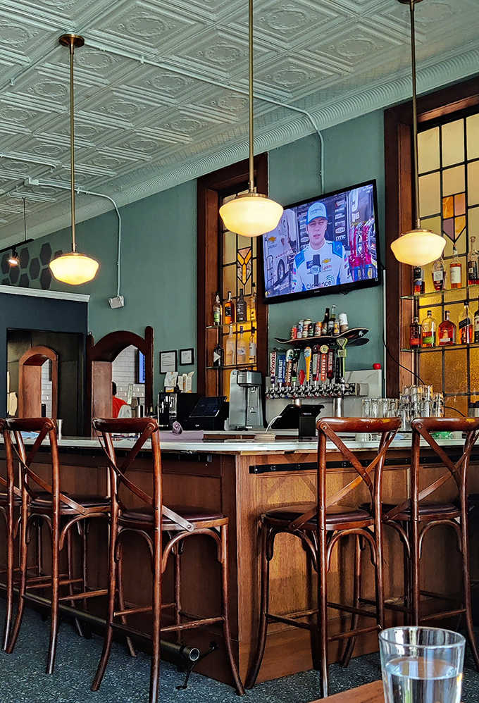 Warm wood tones and stained glass accents create an atmosphere where strangers become friends over shared appreciation of malted excellence.