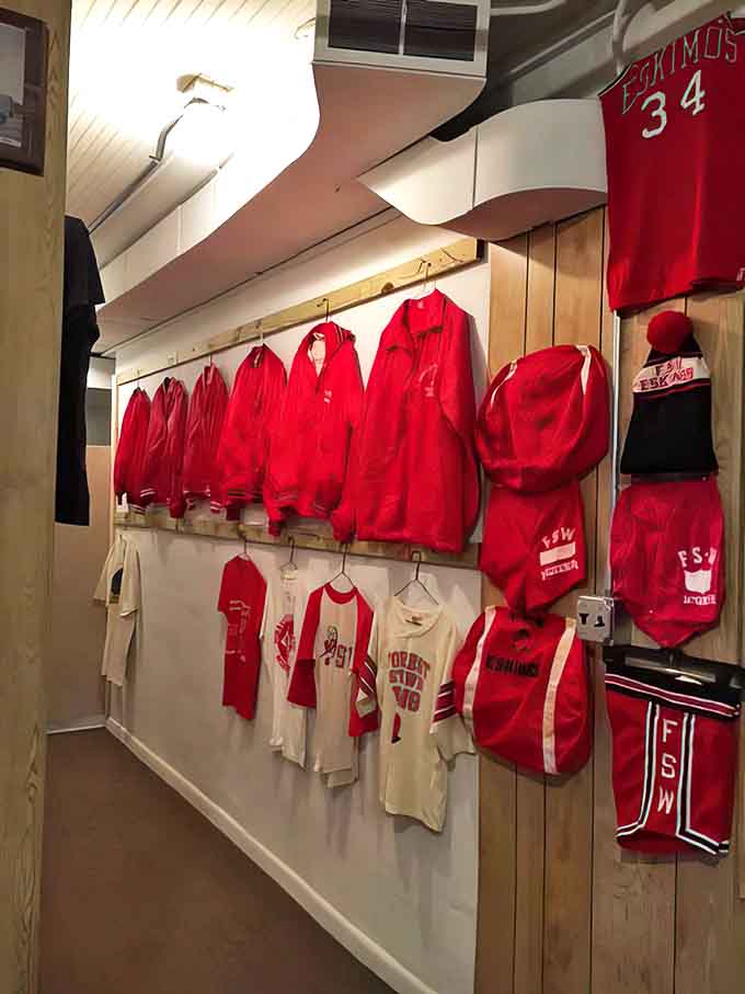 Vintage athletic gear hangs in reverent display, preserving the glory days of local sports heroes and championship seasons.