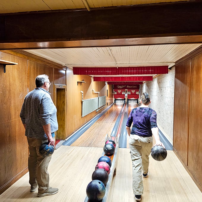 Bowlers prepare for their approach on lanes worn smooth by over a century of footsteps, each depression a testament to history.