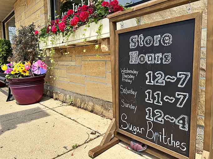 The store hours chalkboard stands like a sentry, guarding the precious information of when sugar-seekers can get their next fix.