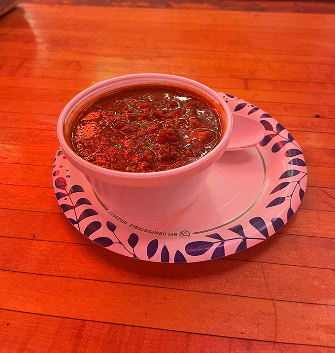 Chilis: This hearty bowl of homemade chili, accompanied by cheese and onions, showcases the kitchen's talent beyond their famous burgers.