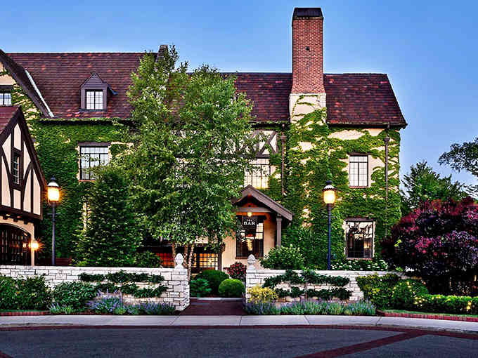 Evening transforms the exterior into a fairytale setting, where Tudor architecture glows with warmth against the darkening sky.
