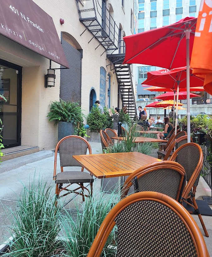Outdoor seating creates an urban oasis where lucky patrons savor their treasures under bright umbrellas, watching the city hustle by.
