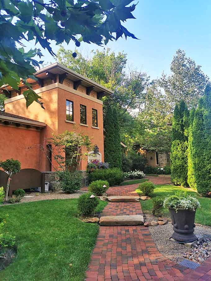 Winding brick pathways lead through manicured gardens, inviting exploration and the distinct feeling you've stumbled into a secret European retreat.