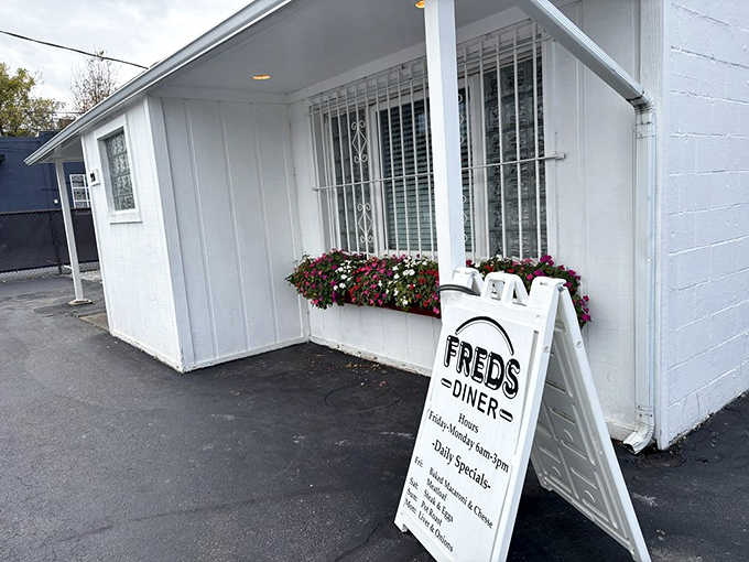 Fred's exterior welcomes hungry visitors with a simple white facade, colorful flower boxes, and the promise of honest, delicious food inside.