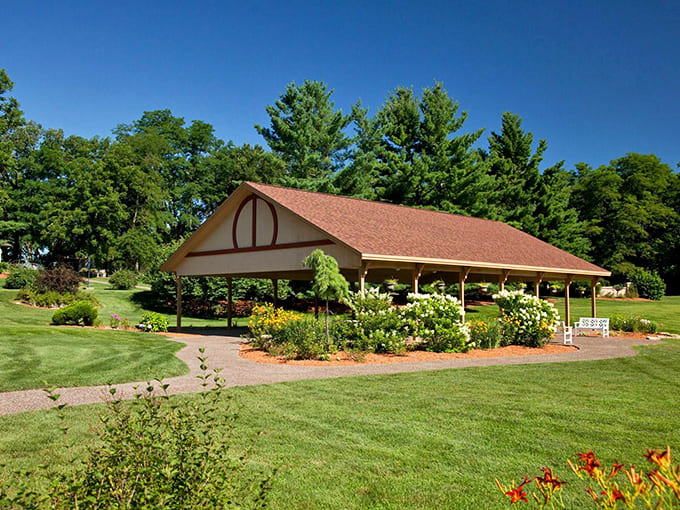 This open-air pavilion surrounded by summer blooms stands ready for gatherings where nature provides the most spectacular backdrop.