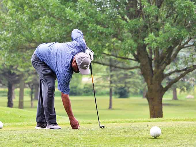 A golfer lines up his shot with deliberate focus, embodying the unhurried approach to life that makes Richton Park a stress-free haven.