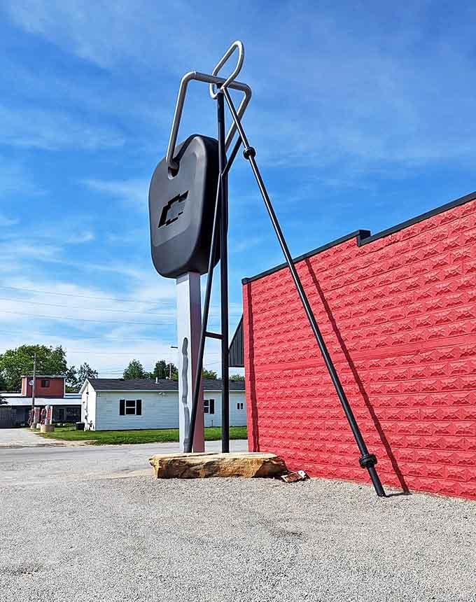 The juxtaposition of ordinary and extraordinary: a perfectly normal building beside a completely abnormal truck key.