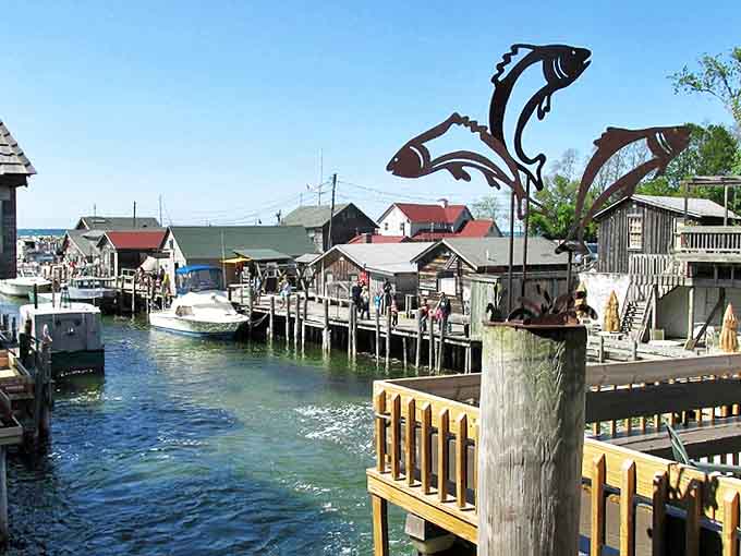 Metal fish sculptures dance above the boardwalk, celebrating the catch that built this community one scale at a time.