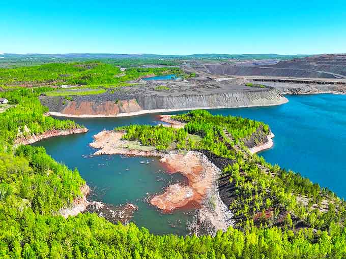 Bird's-eye brilliance reveals the intricate relationship between water, forest and mining at Leonidas, where blue lakes form perfect mirrors of the sky.