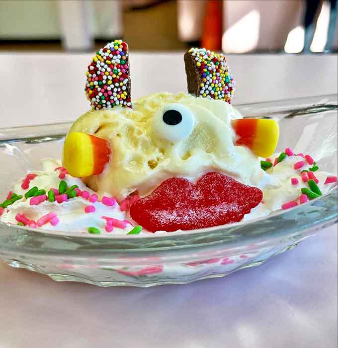Ice cream artistry at its finest – this whimsical creation turns dessert into a character with candy ears and a cherry smile.