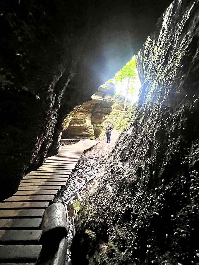 Light at the end of the tunnel &ndash; this wooden pathway leads explorers through dark cave passages toward the bright promise of daylight.