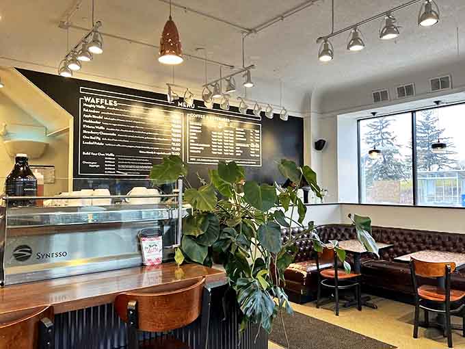 Plants and natural light soften the industrial elements, creating a space that feels both urban and organic.