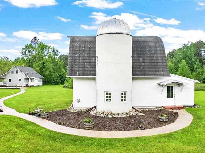 From another angle, you can appreciate how the barn and silo create a picturesque silhouette against the landscape – countryside perfection captured in architecture.