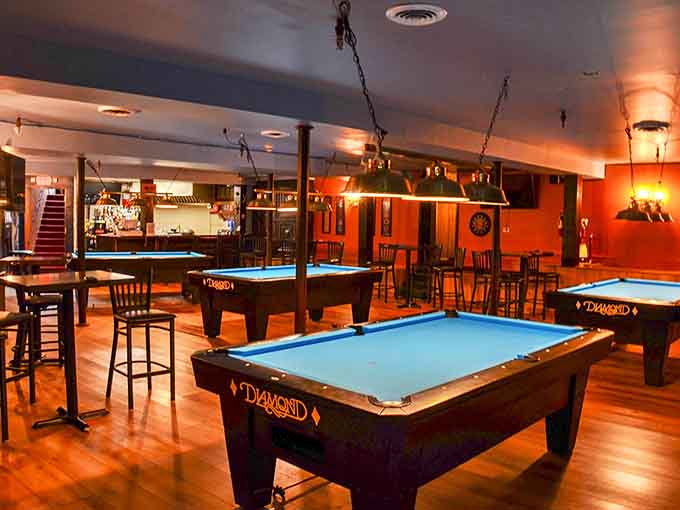 The lower level's pool tables invite friendly competition under warm lights, where strangers become friends over a game and a second round.