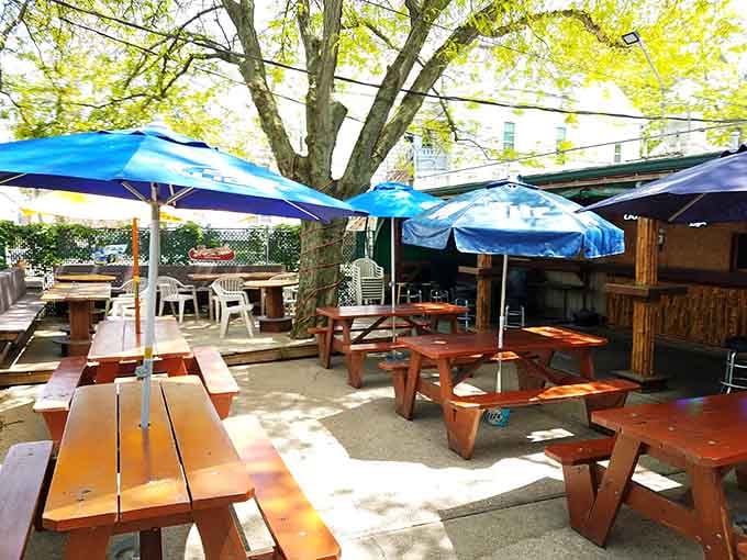 Picnic tables under blue umbrellas provide the perfect warm-weather dining option, letting you enjoy your meal with fresh air.