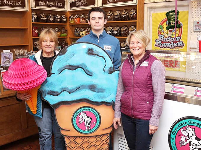 The friendly staff poses with their mascot, proving that the people behind the counter are just as sweet as the treats they sell.