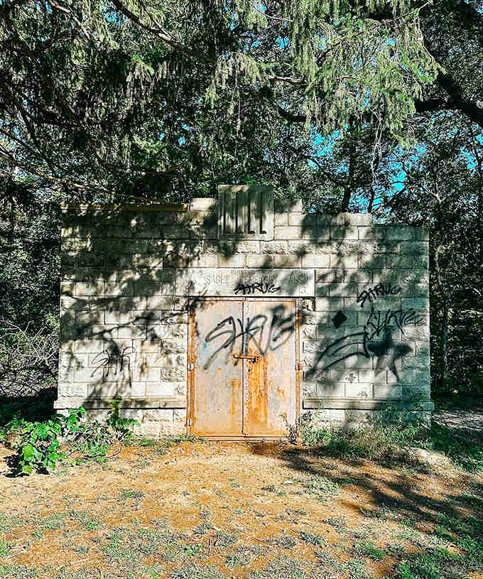 Once a caretaker's building perhaps, this stone structure now stands as a weathered sentinel with secrets locked behind its rusted doors.