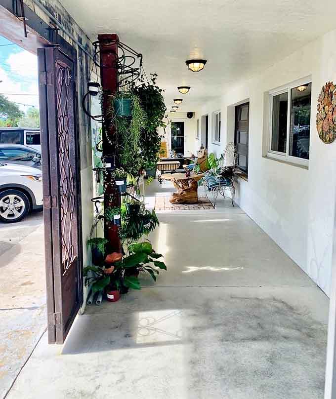 Plant-lined walkways create secret garden passages between spaces, inviting exploration beyond the main caf&eacute; area into hidden corners of delight.
