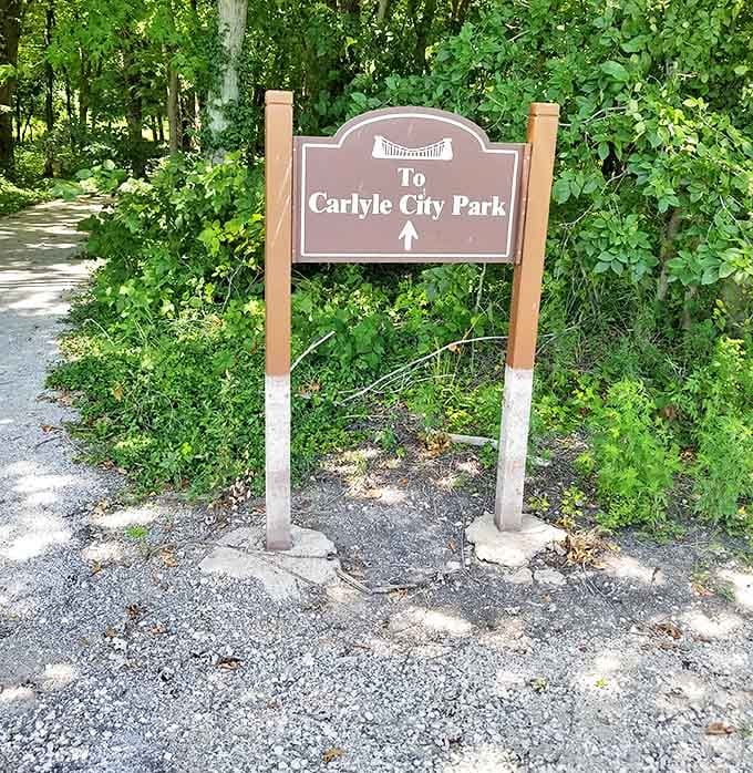A simple sign marks the entrance to Carlyle City Park, where urban amenities meet natural beauty along the lake's edge.