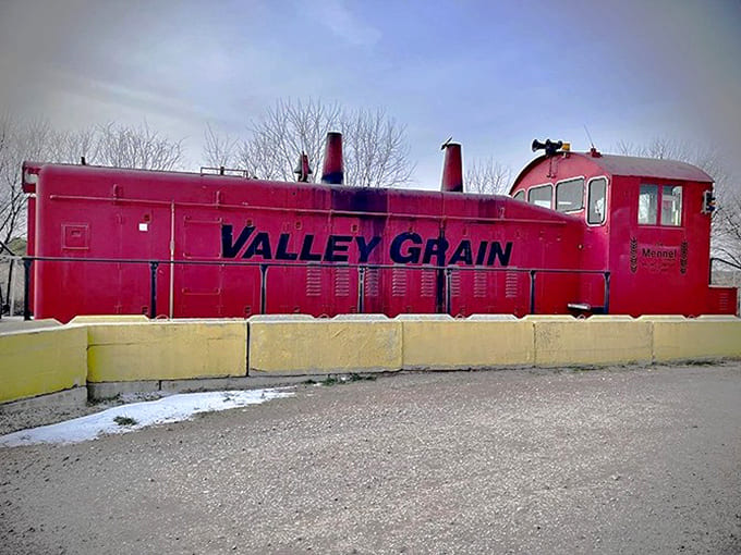 The Valley Grain locomotive's bright red paint has weathered with dignity, much like the town it once served.