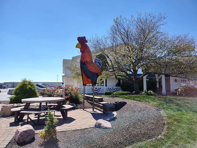 Outdoor seating with a towering rooster statue provides a whimsical photo opportunity and pleasant dining option during nice weather months.