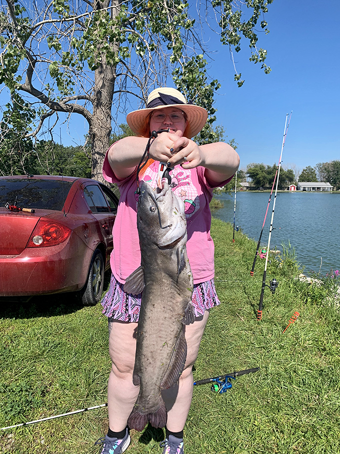 A proud angler displays her impressive channel catfish catch, the reward of patience at the park's well-stocked fishing pond.