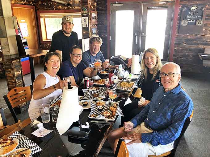 Happy diners sharing a feast of barbecue treasures, their expressions revealing that universal moment when great food creates lasting memories.