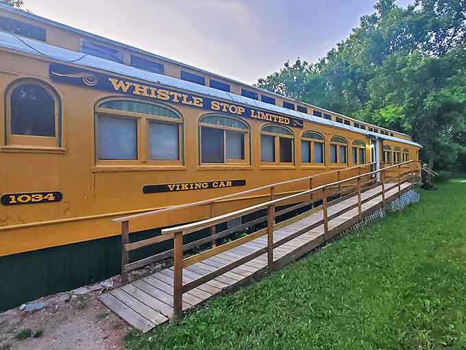 The yellow passenger car welcomes visitors with its vintage charm, promising a night of stationary travel through time.