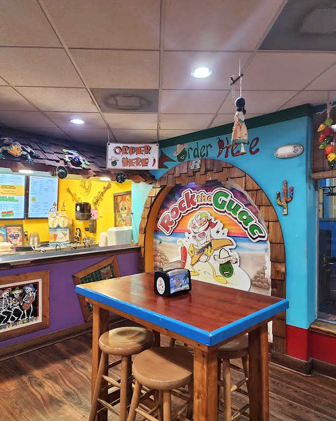 The interior blends playful tiki aesthetics with beachy charm. "Rock the Guac" mural suggests someone here has a serious sense of humor about their serious ice cream.