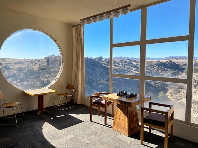 Chess by the window? The interior lounge pairs strategic thinking with strategic views, framing the desert through perfect circles.