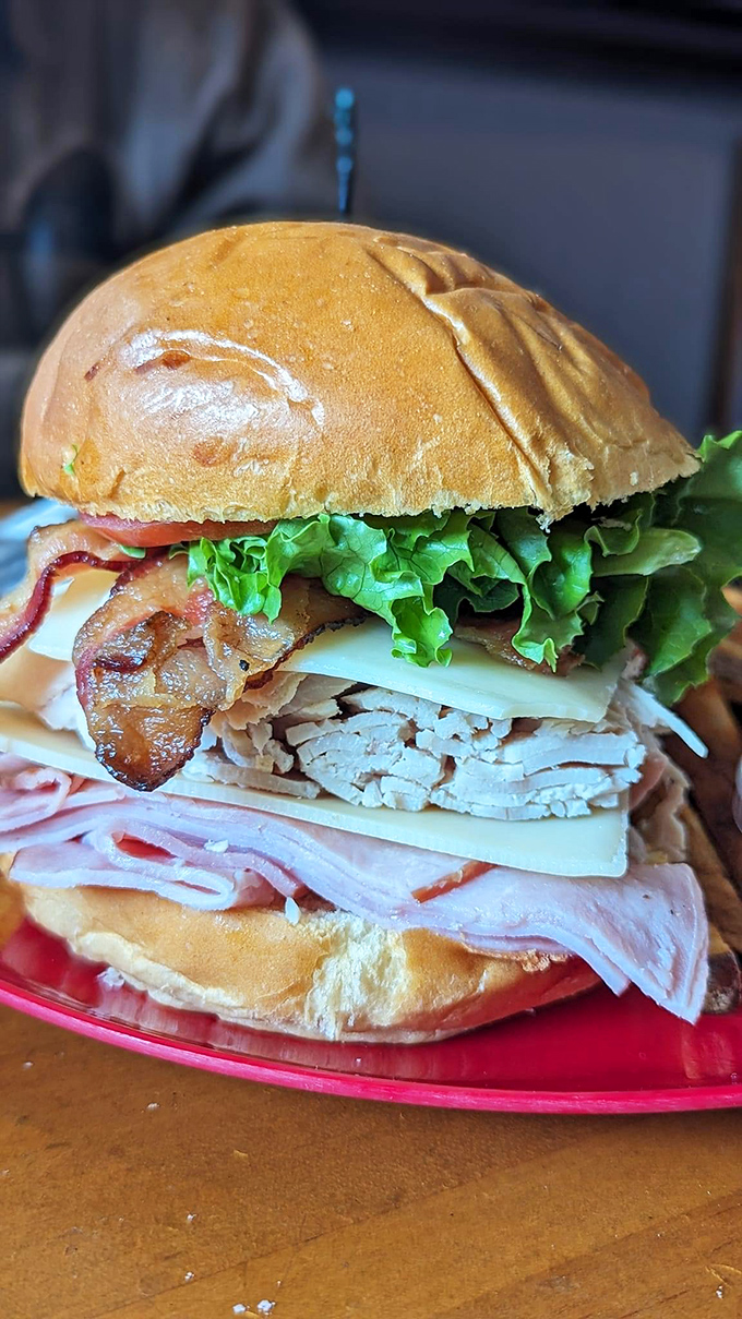 This towering club sandwich demonstrates Gasoline Alley's philosophy: why settle for ordinary portions when you can create something magnificently excessive?