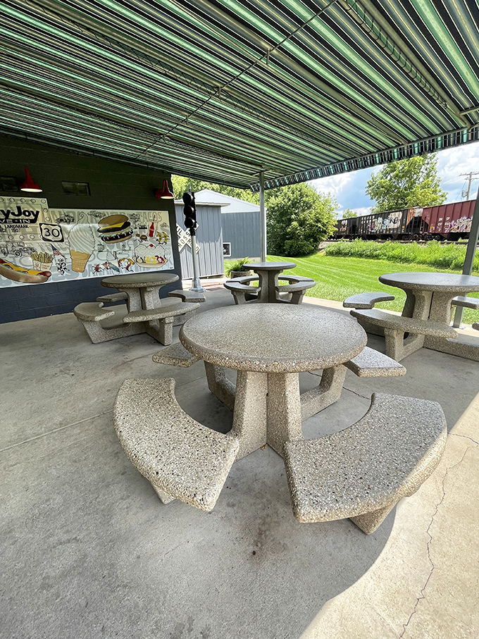 Concrete picnic tables under striped awnings offer the perfect spot to watch trains rumble by while racing to finish your cone before it melts.