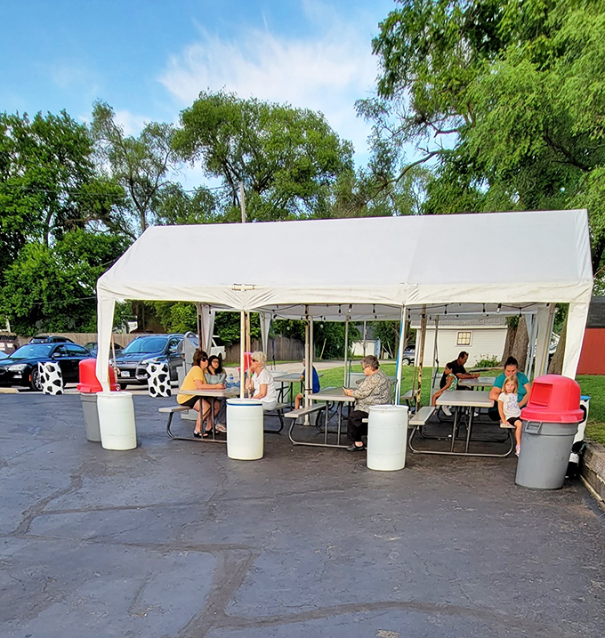 The outdoor seating area transforms into an impromptu community gathering, where strangers become friends united by brain freeze and happiness.