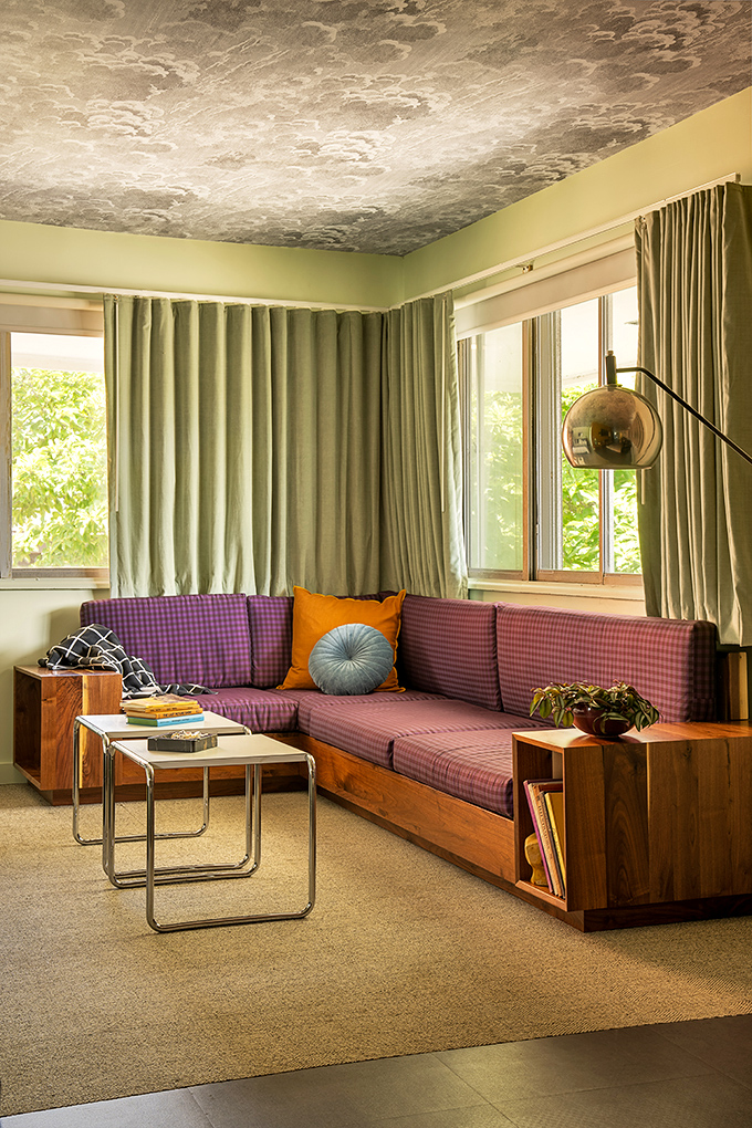 The conversation pit-inspired seating area invites lazy afternoons with a good book under that remarkable cloud-patterned ceiling.