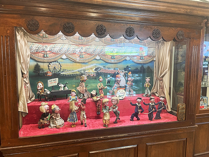 This charming mechanical display cabinet houses vintage figurines in a miniature fairground scene that captivates diners of all ages.