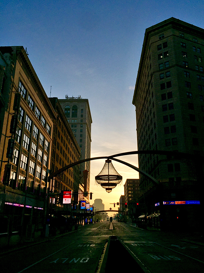 Sunset silhouettes the chandelier against Cleveland's skyline, creating that magical moment when day surrenders to the chandelier's domain.