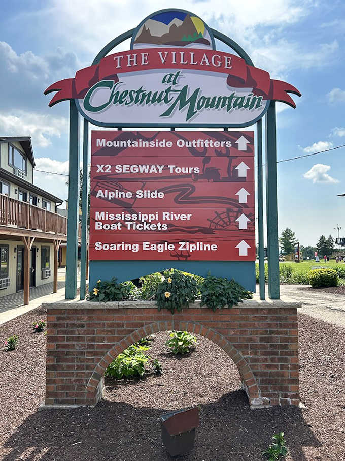 The Village at Chestnut Mountain sign promises multiple adventures, but the Alpine Slide remains the undisputed star attraction.