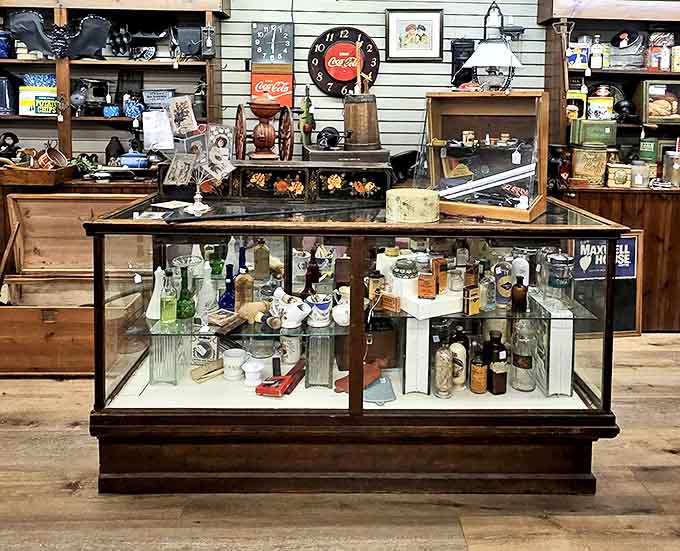 Vintage Coca-Cola memorabilia shares space with antique bottles &ndash; everyday advertising transformed into collectible Americana through the magic of time.