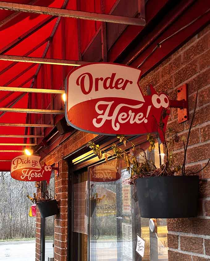 That retro "Order Here!" sign points the way to burger paradise with cheerful certainty, guiding hungry pilgrims to their delicious destination.