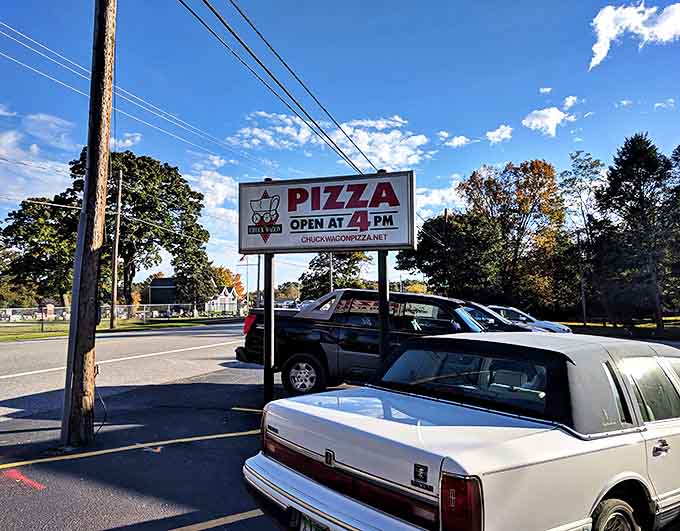 The roadside sign beckons hungry travelers with a simple promise &ndash; great pizza awaits just beyond those doors at 4 PM sharp.