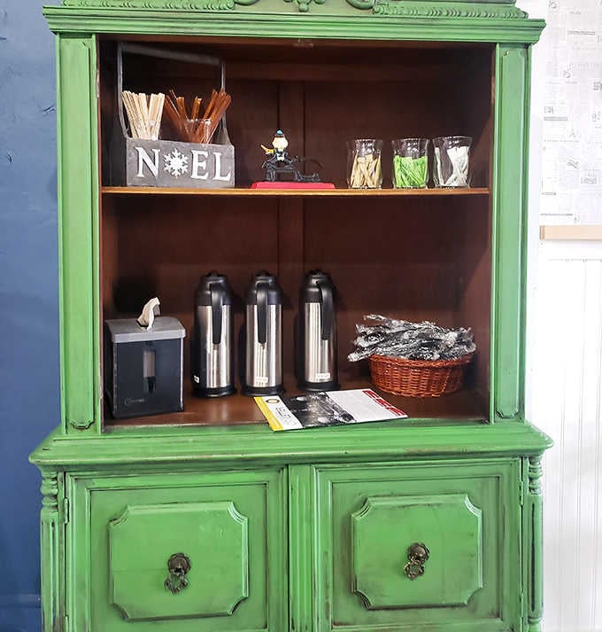 That vintage green cabinet has been promoted from storing someone's dishes to holding coffee supplies, living its best repurposed life in the process.