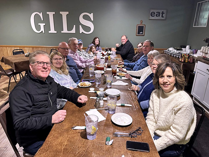 Happy diners gathered around Gil's table &ndash; where strangers become friends and friends become family over plates of comfort food.