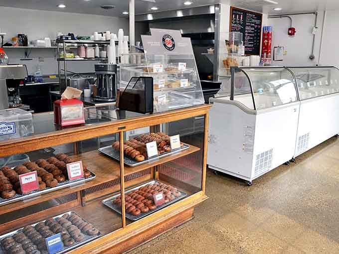 This display case doesn't just hold baked goods – it showcases edible art forms that make diets crumble faster than their perfectly baked cookies.