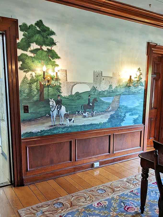 Painted scenes transport viewers to imaginary landscapes where hunters and hounds pursue adventure across walls that refuse to be merely functional.