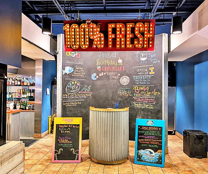 The "100% Fresh" illuminated sign isn't just decorative&mdash;it's a promise delivered with every juicy, cheese-filled bite at The Patty Wagon.