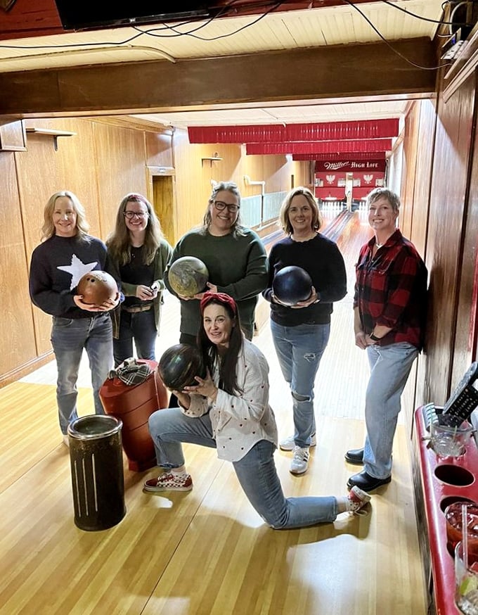 A group of bowlers poses with their vintage equipment, creating new memories in a space where time seems wonderfully suspended.