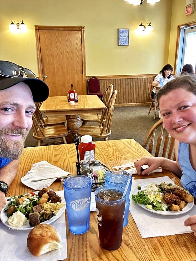Happy diners enjoying plates piled high with homestyle favorites &ndash; the universal expression of "I'm going to need a nap after this."