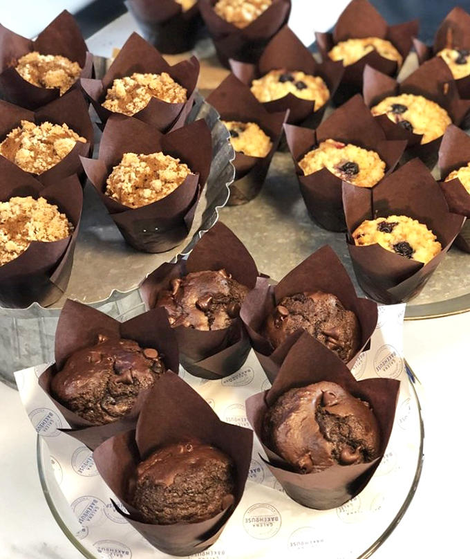 Muffins nestled in their paper cups like tiny, perfect gifts. Each one promises a different flavor adventure, from chocolate decadence to fruity bliss.